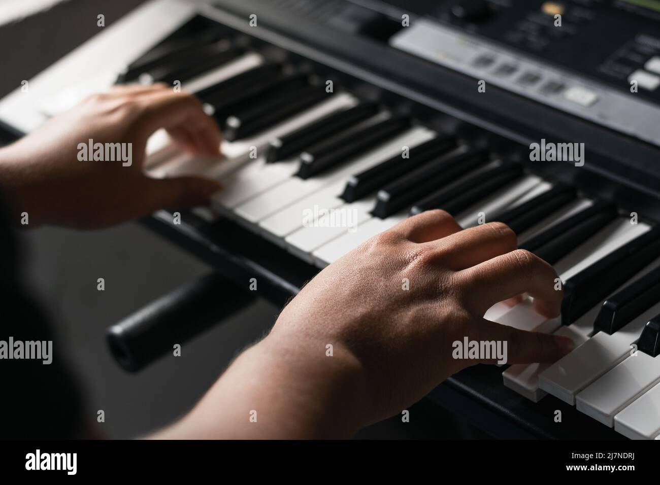 man playing synthesizer at home, taking virtual lessons, playing low ...