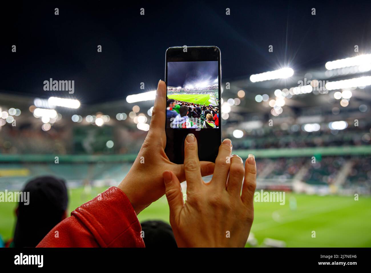 Fan hand with smartphone photographing football match. Using mobile ...