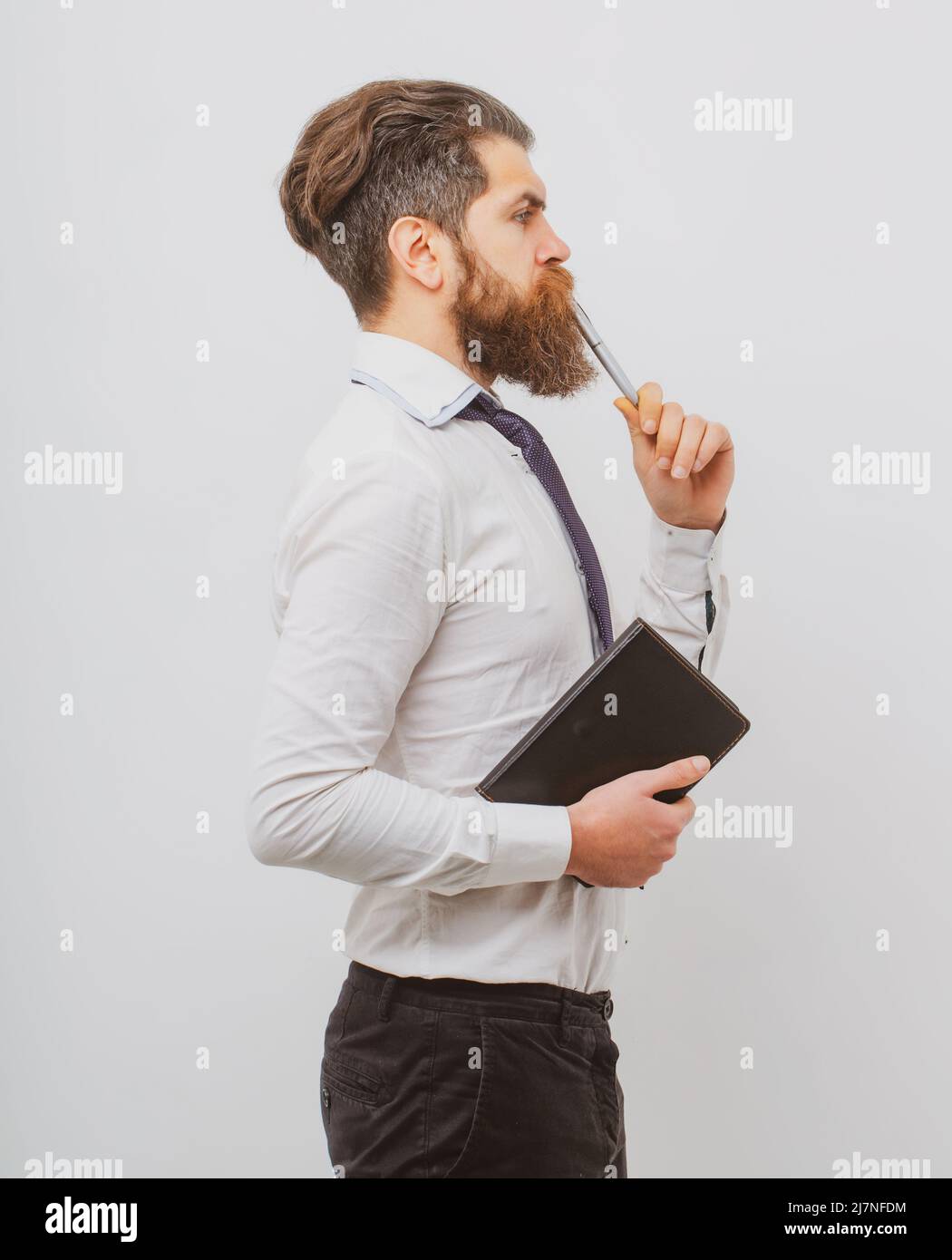 Concentrated man with pen in his mouth. Male with notepad for writing ...