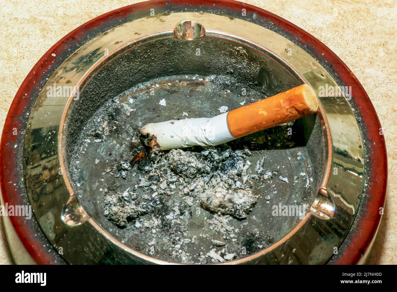 Cigarette butt in an ashtray on the table. The concept of the dangers of smoking Stock Photo - Alamy
