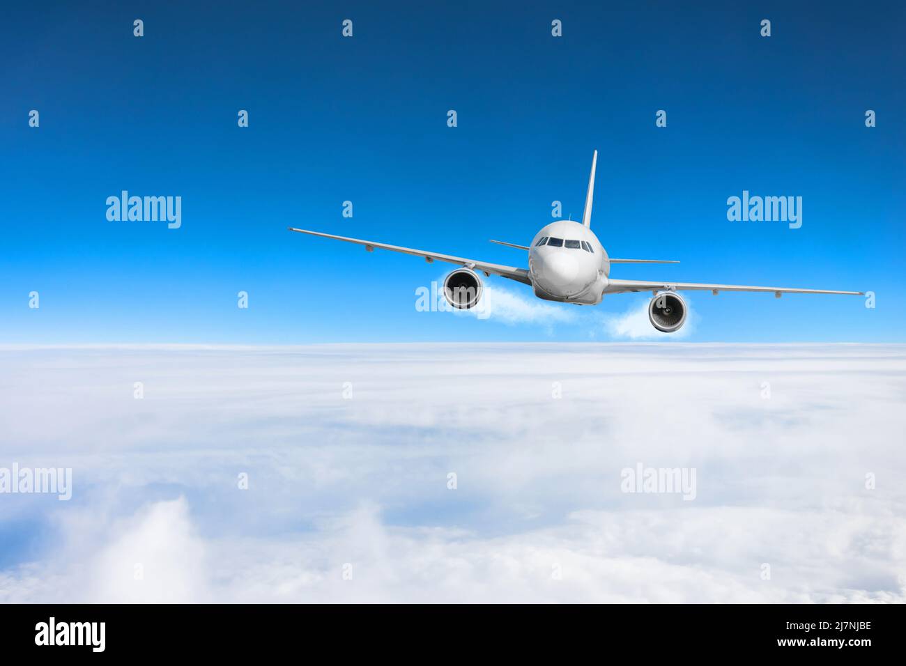 Airplane fly over the clouds and the earth's surface under the blue sky ...
