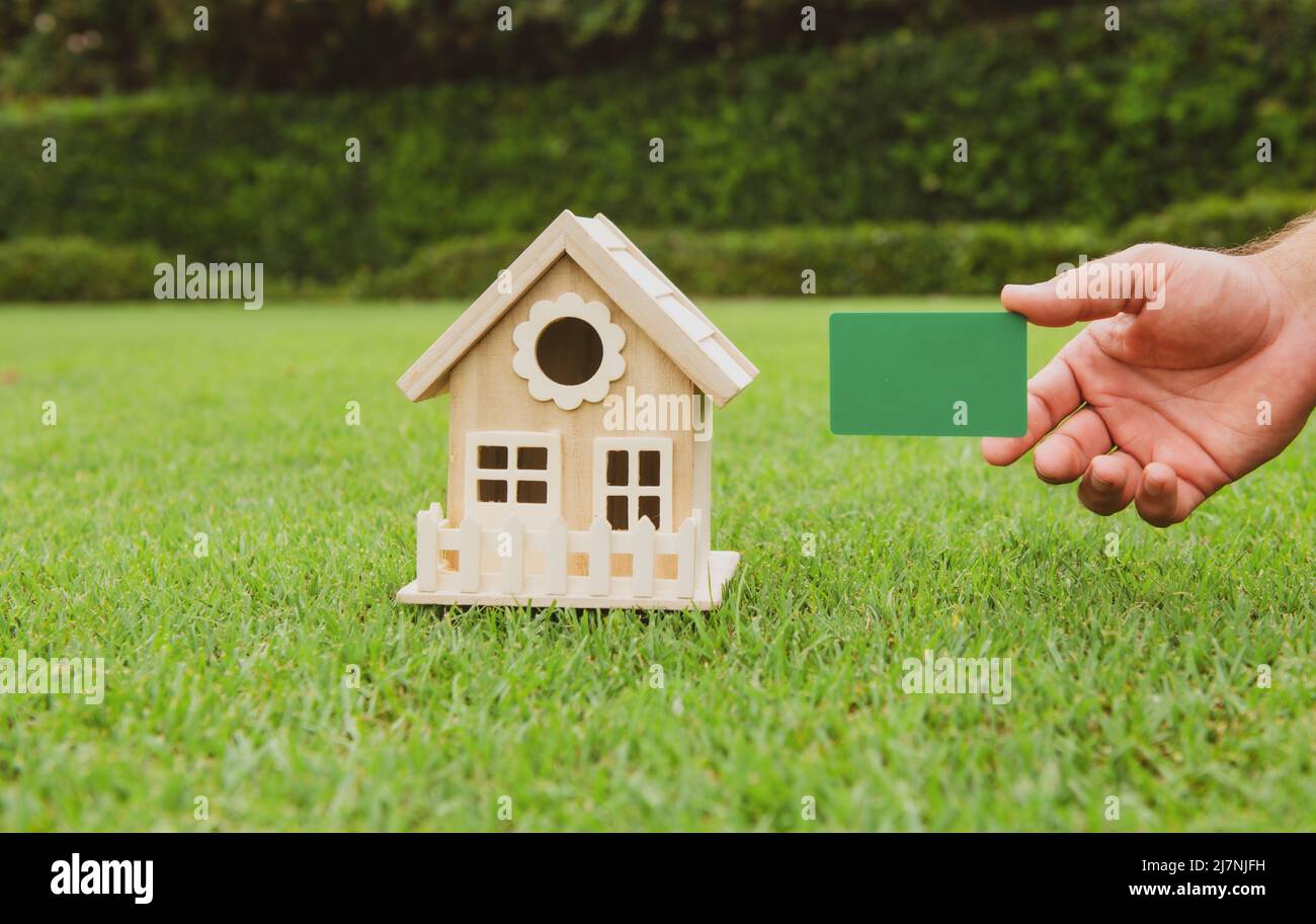 Toy house and credit card in hands. Mortgage and housing estate concept ...