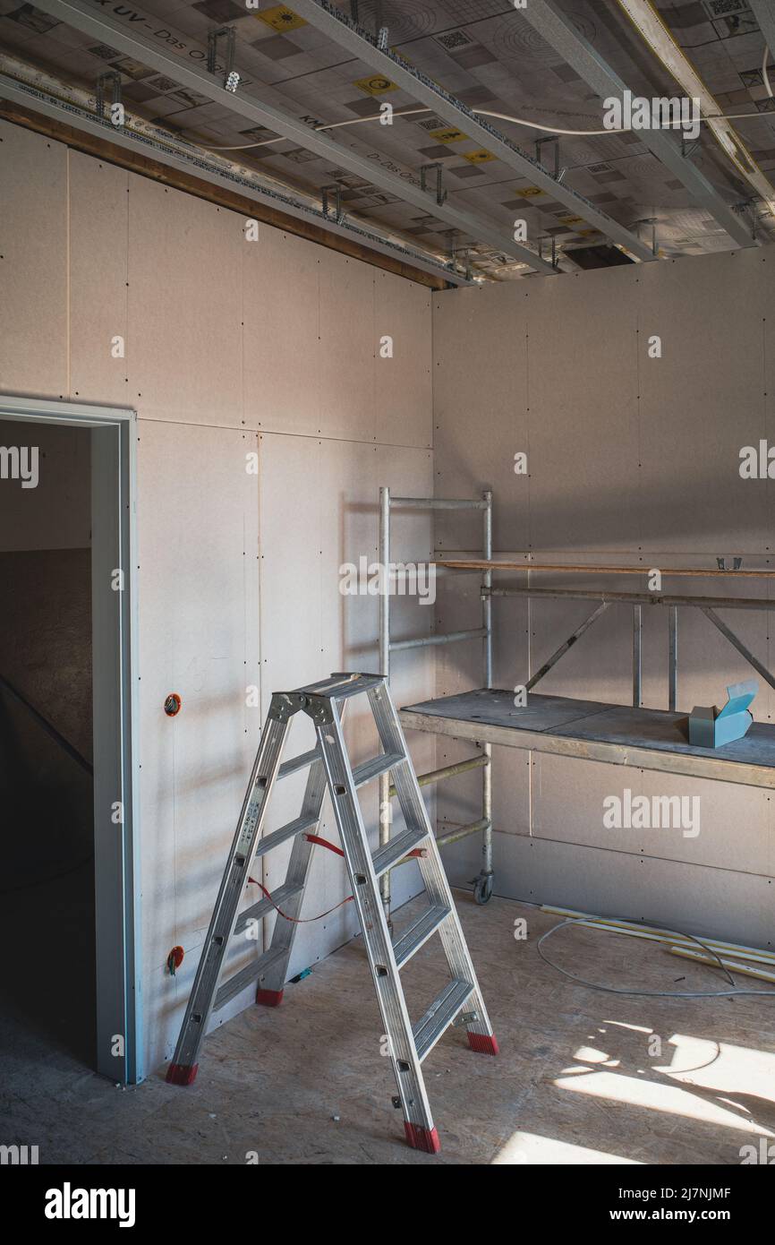 a folding ladder and a small scaffold stand in a room on a construction ...