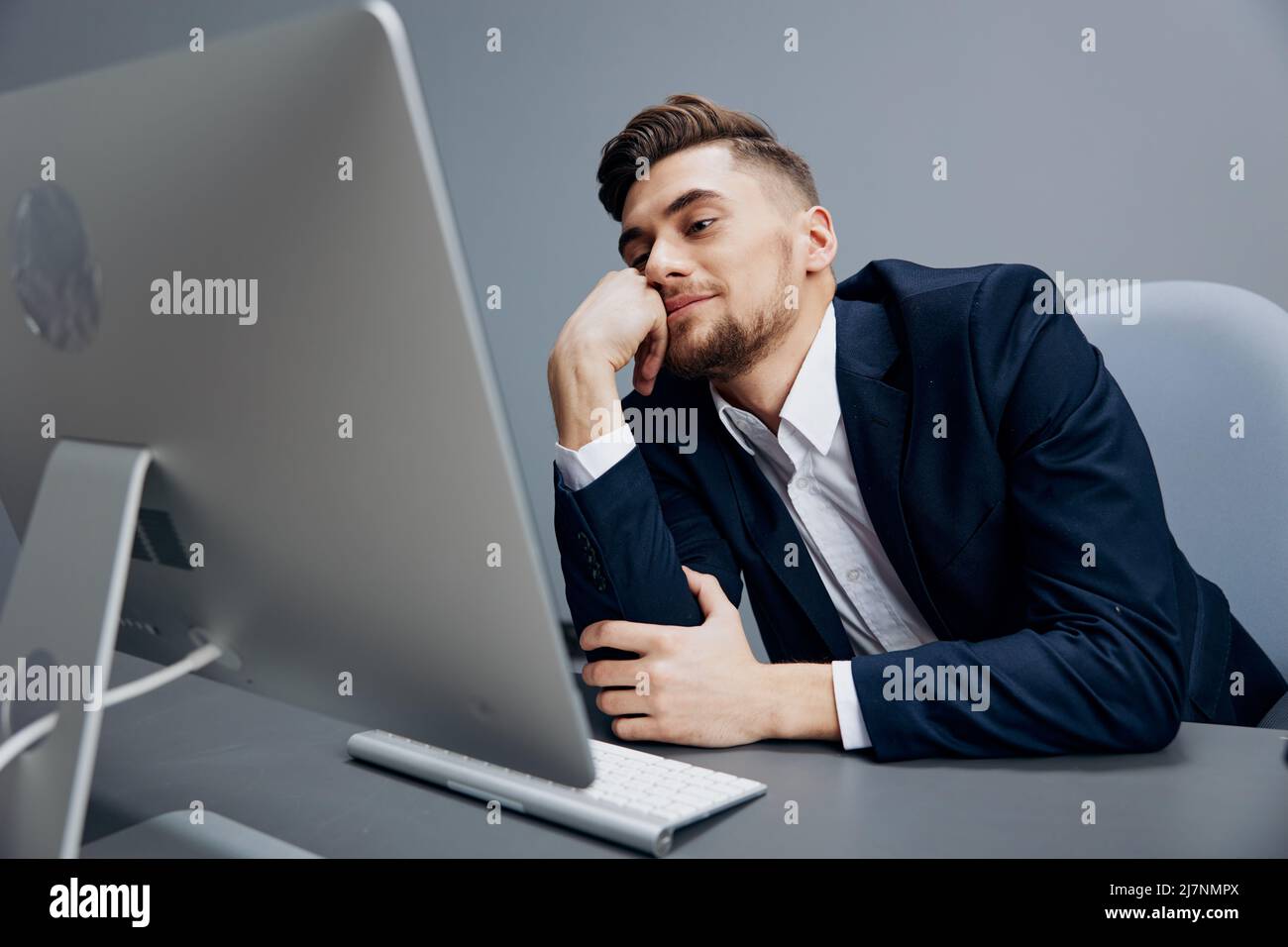 manager tired glass of coffee works in front of a computer Gray ...
