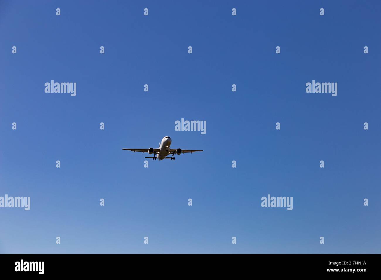 Airplane flying on the blue sky background Stock Photo - Alamy