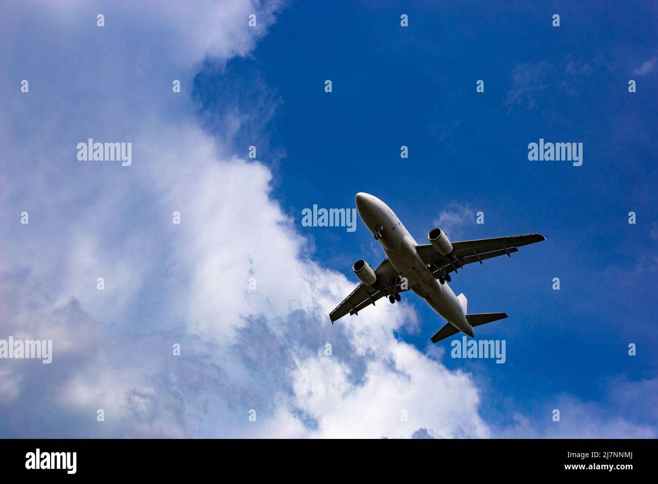 Passenger airplane in blue sky Stock Photo - Alamy