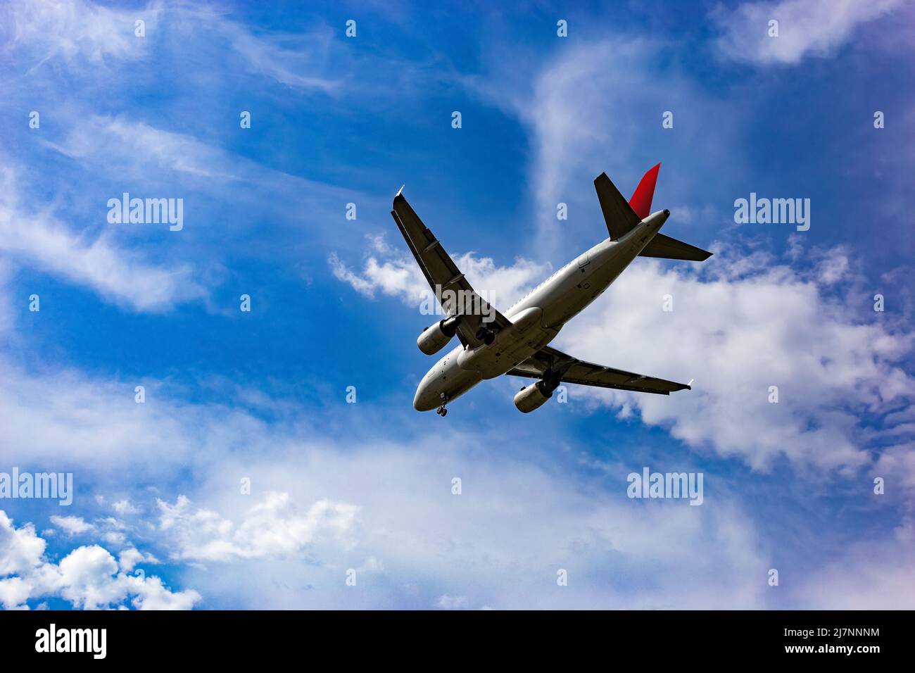Passenger airplane in blue sky Stock Photo - Alamy