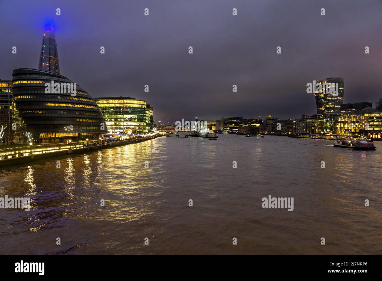 London at twilight, lights sparkling either side of the Thames, taken ...
