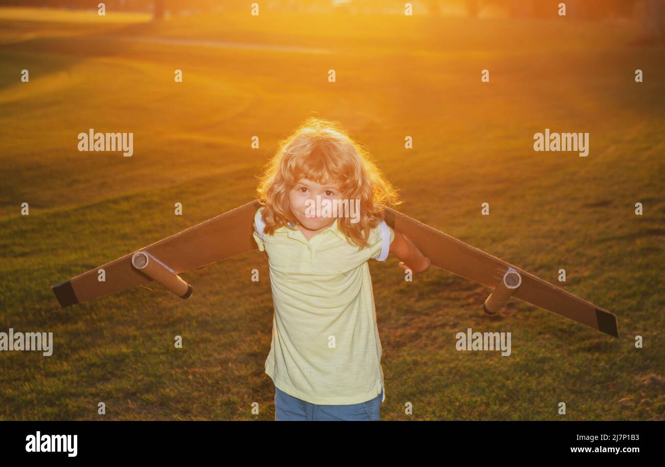 Child playing with toy jetpack at sunset grass field. Child pilot ...