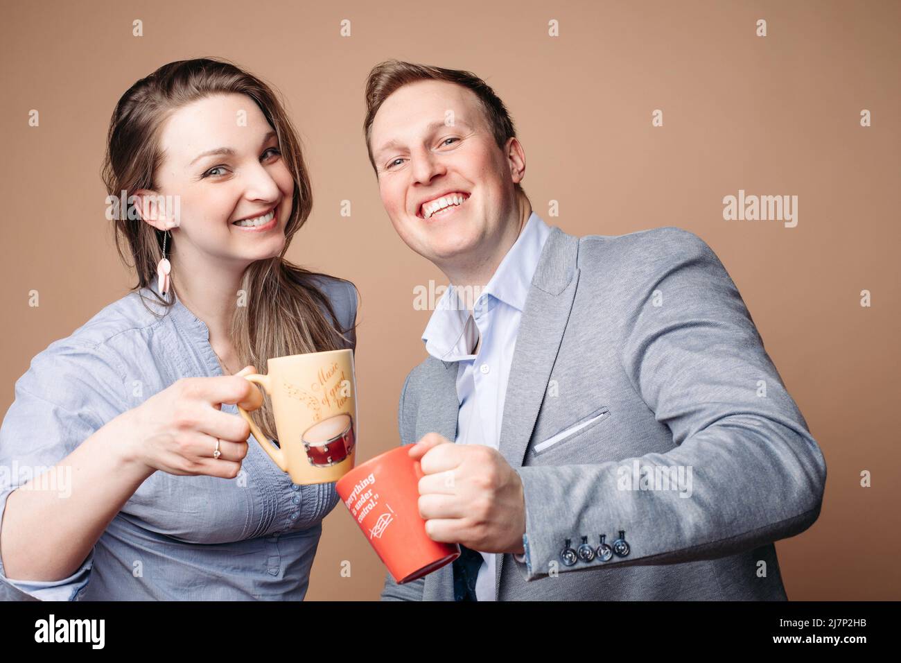 Two beautiful lovers stands with cups and smiles Stock Photo - Alamy