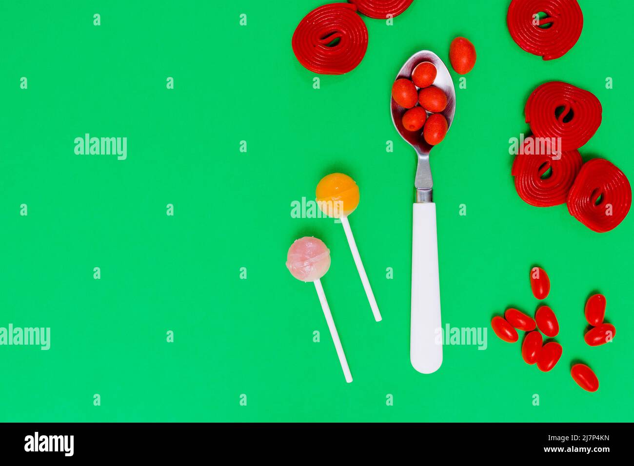 red candies and lollipops on a plain blue background. wallpaper to use ...