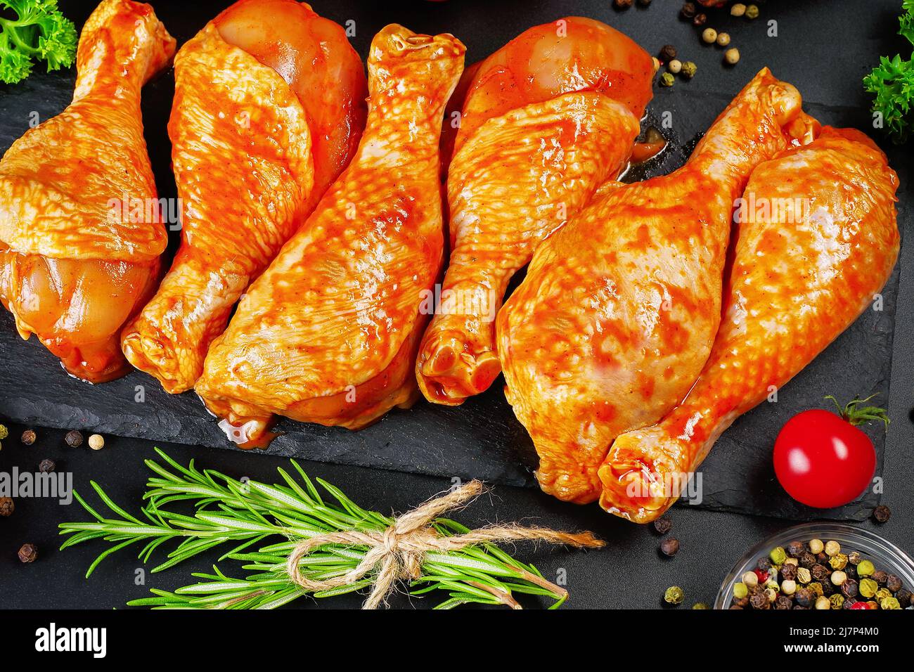 Barbecue marinated chicken dramstick on a black culinary board on a ...
