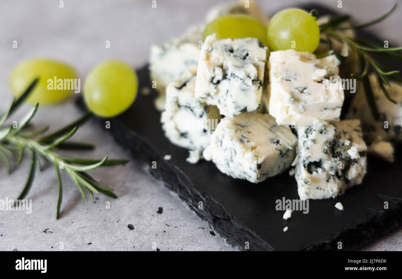 Sliced ??blue cheese on a black stone tray Stock Photo - Alamy
