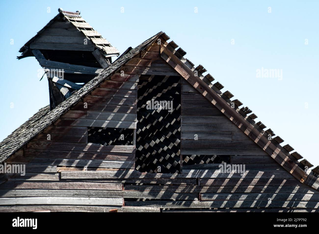 Dilapidated boards cast long shadows on a long forgotten barn in Stock ...