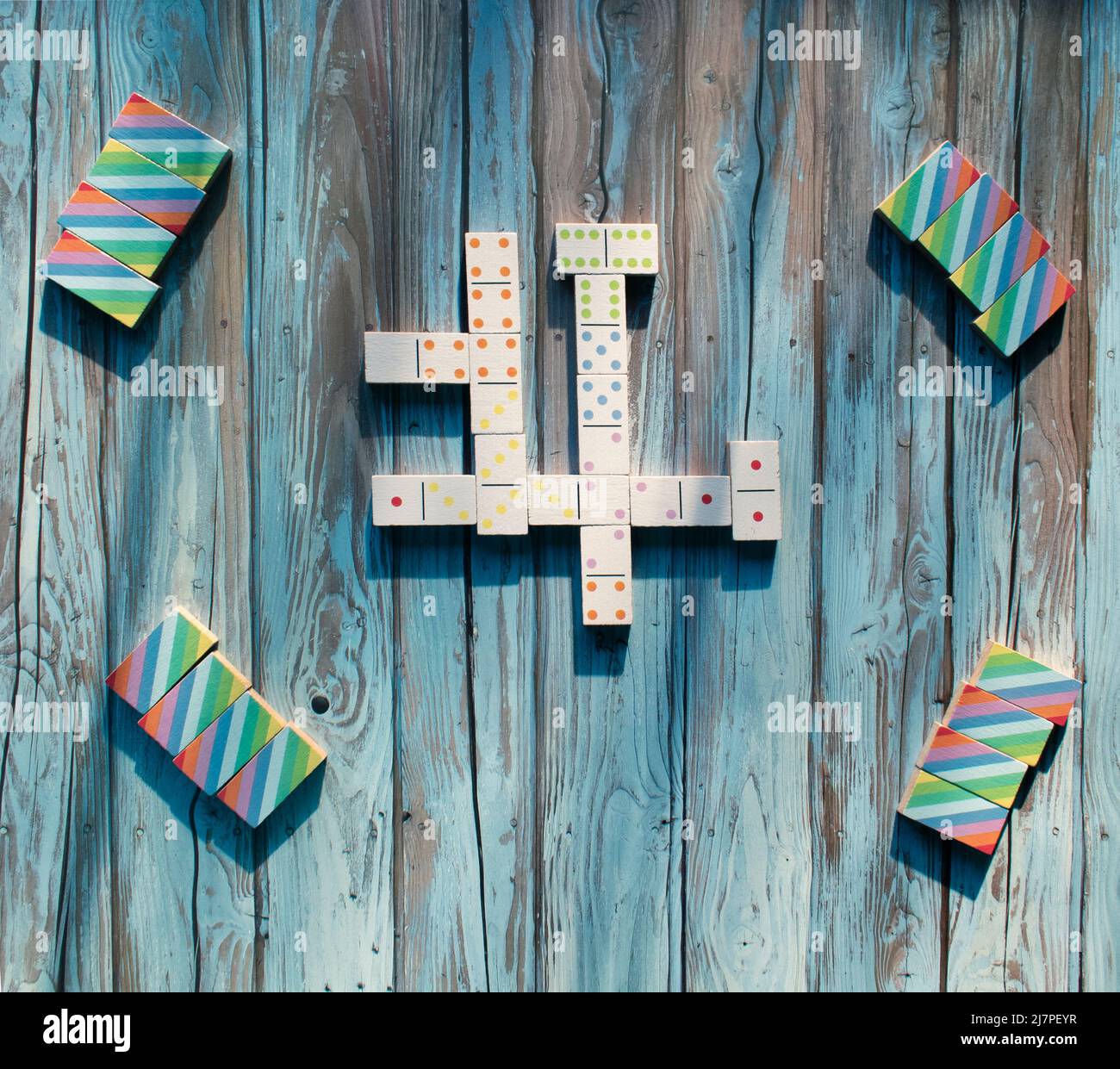 dominoes with colorful print, fallen down on a wood table Stock Photo ...