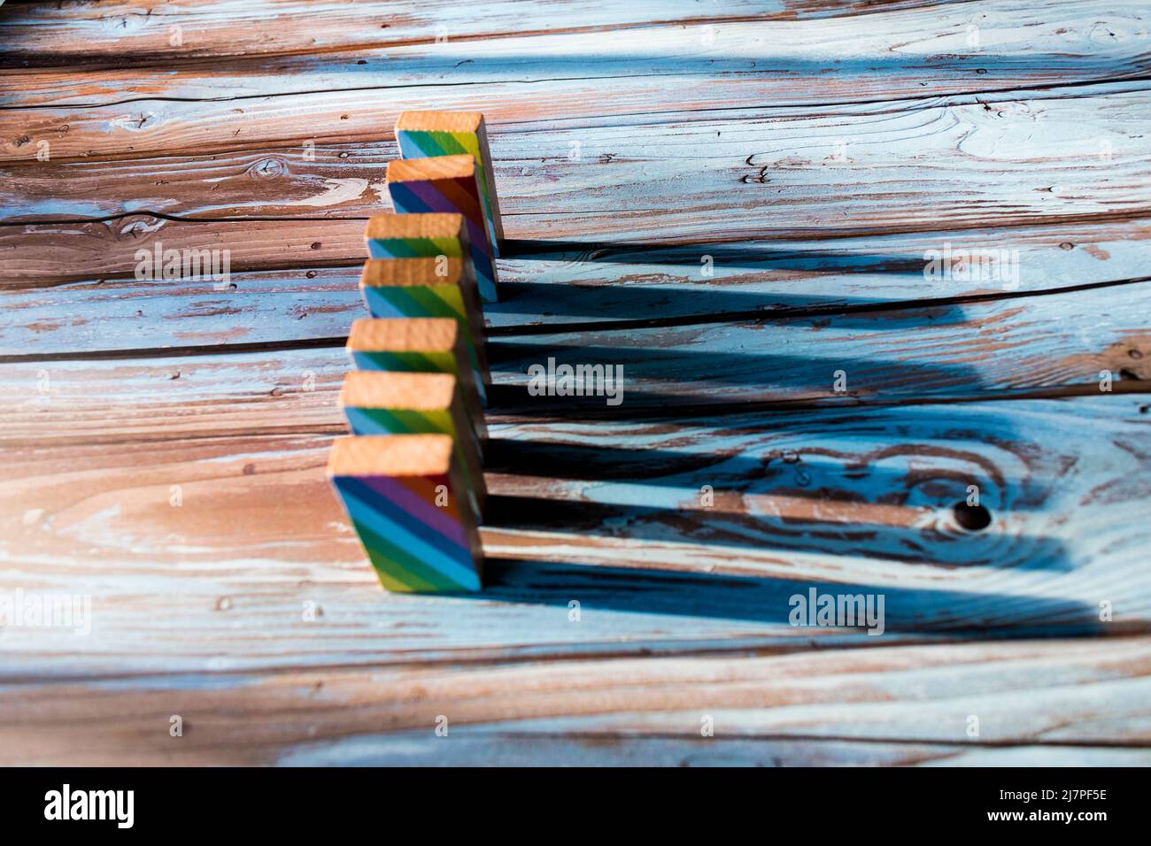dominoes with colorful print, fallen down on a wood table Stock Photo ...