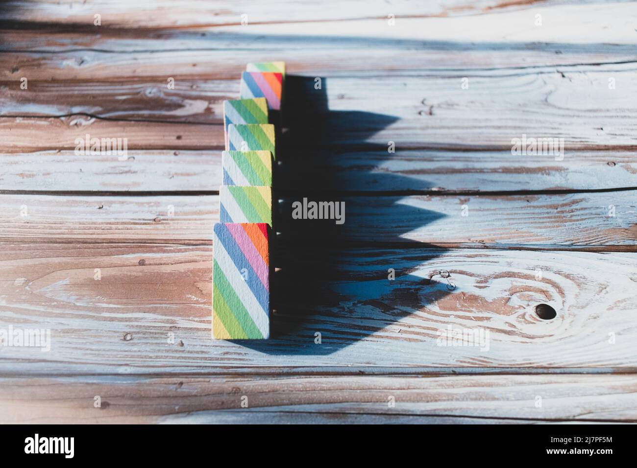 dominoes with colorful print, fallen down on a wood table Stock Photo ...