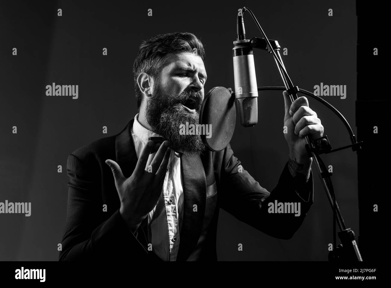 Man with microphone singing in music hall Stock Photo - Alamy