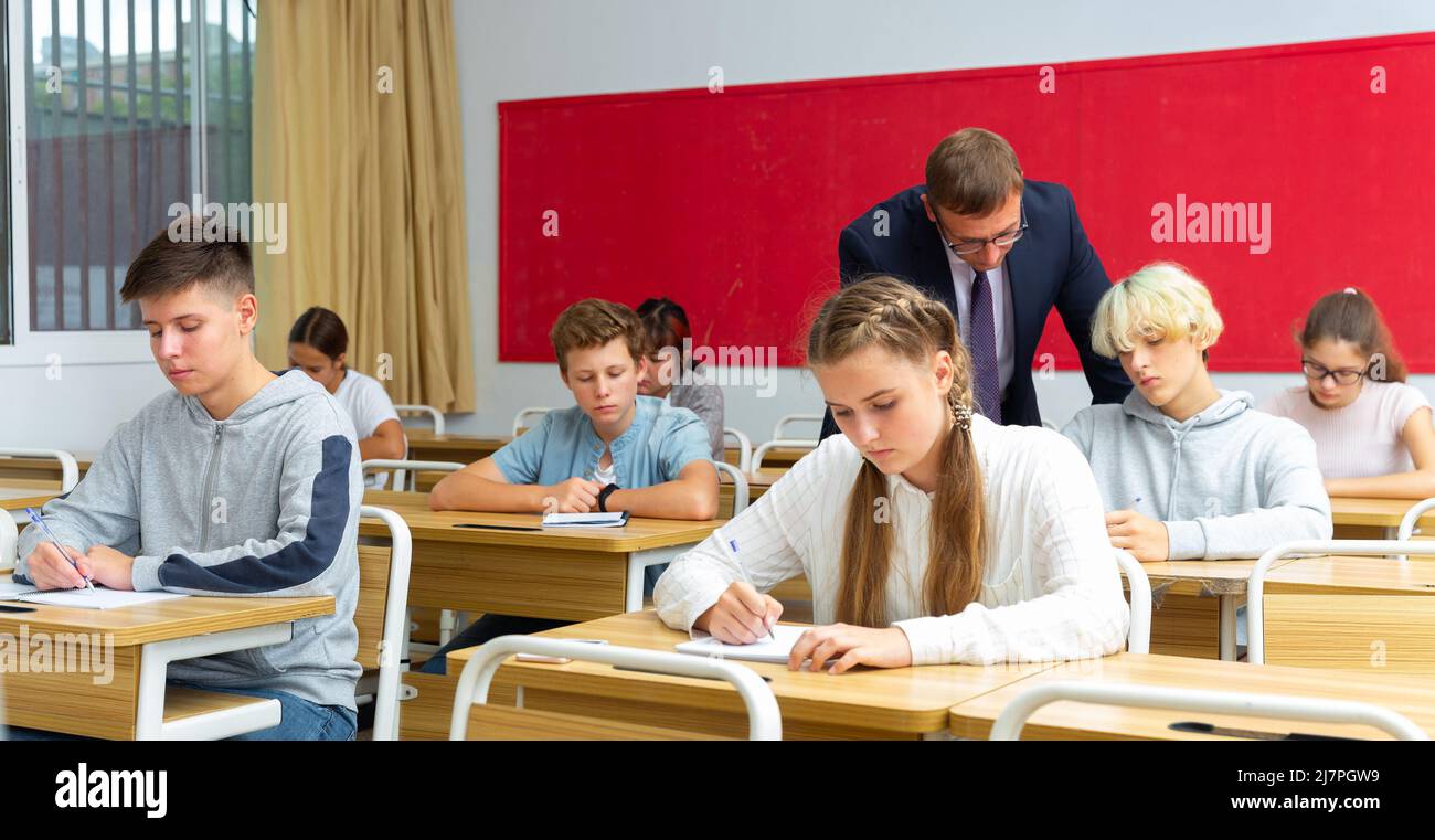 Teenage students working at class during lesson Stock Photo - Alamy
