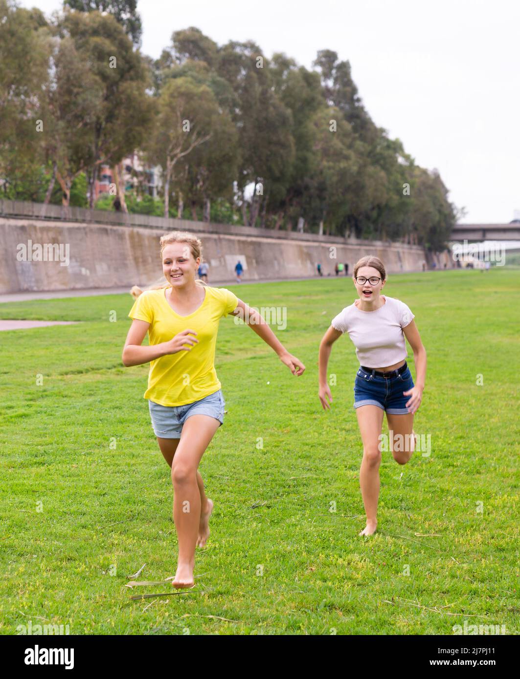 Young barefoot girls running through grass Stock Photo - Alamy