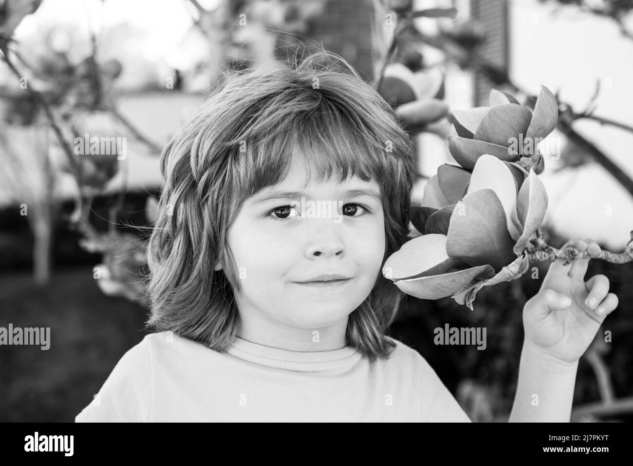 Spring kid with flower tree. Cute child in blossom garden. Happy boy at ...