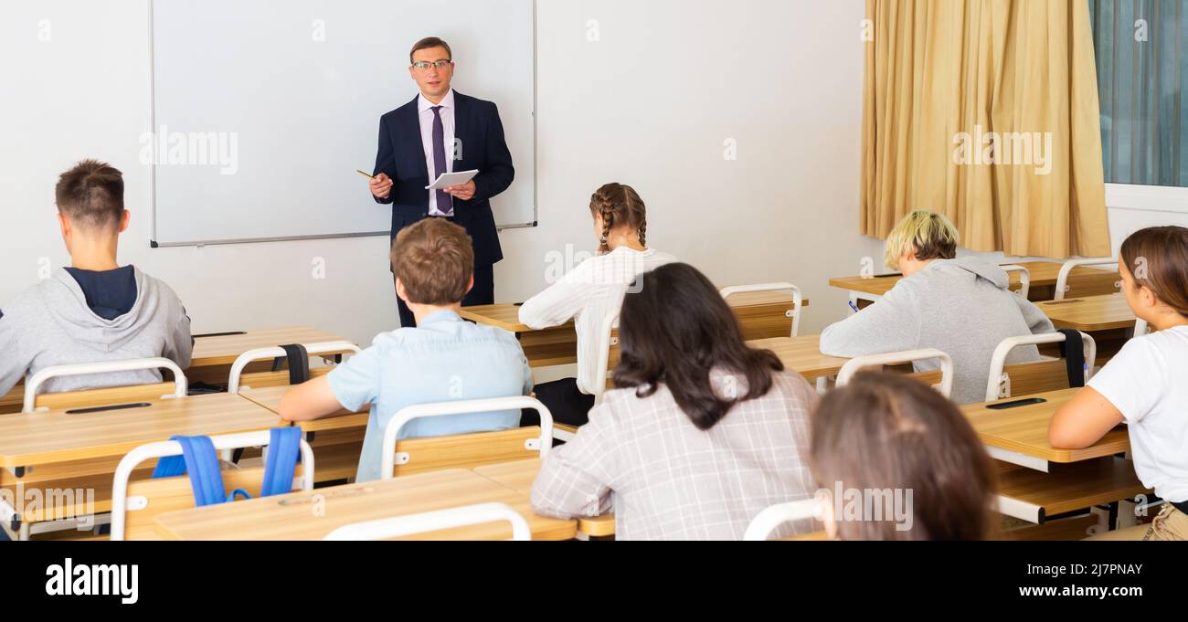 Male teacher lecturing to students at classroom Stock Photo - Alamy