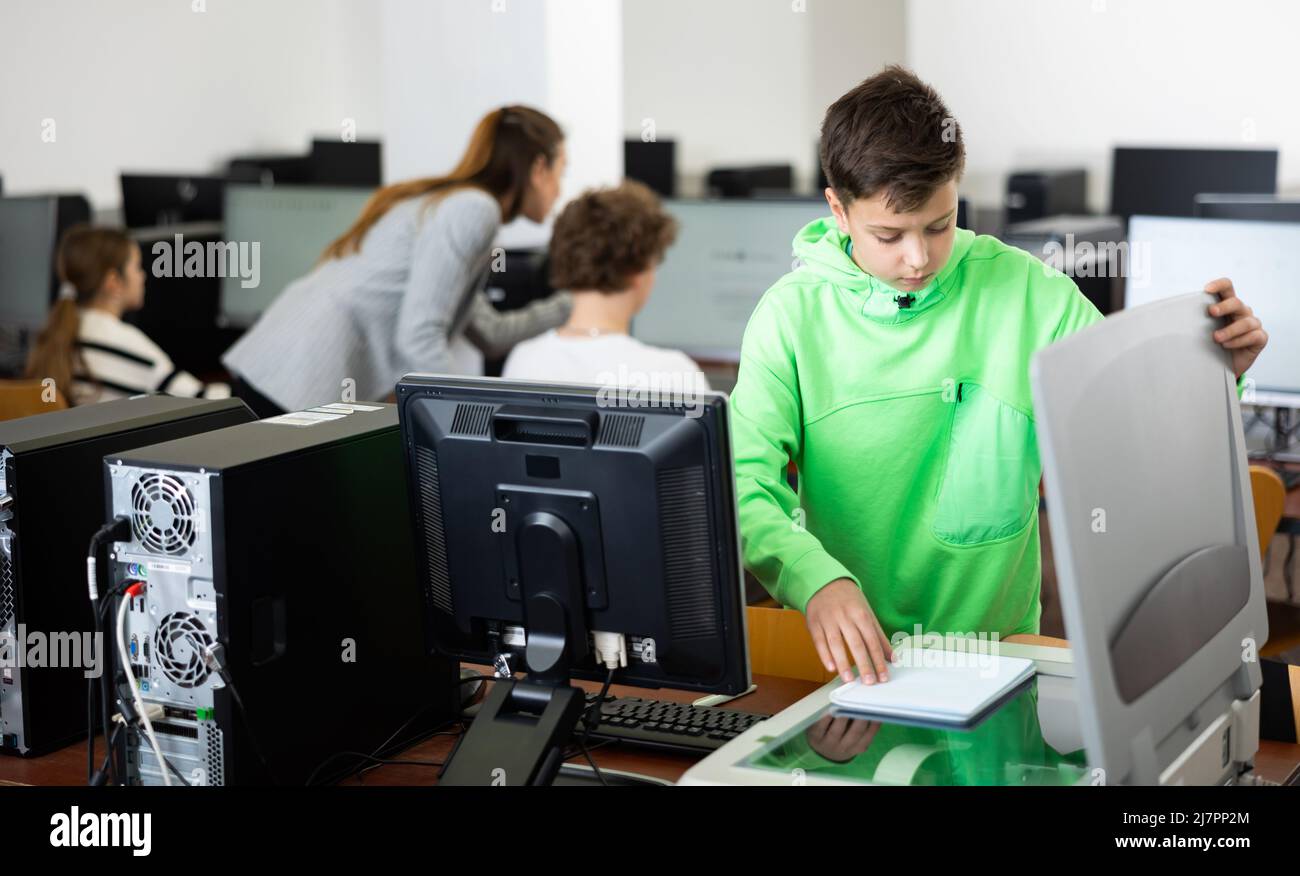Tween schoolboy copying lecture note on copier in computer class Stock ...
