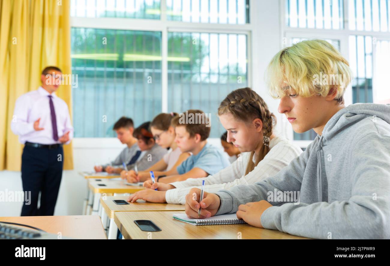 Side view of student group working on lecture in classroom Stock Photo ...
