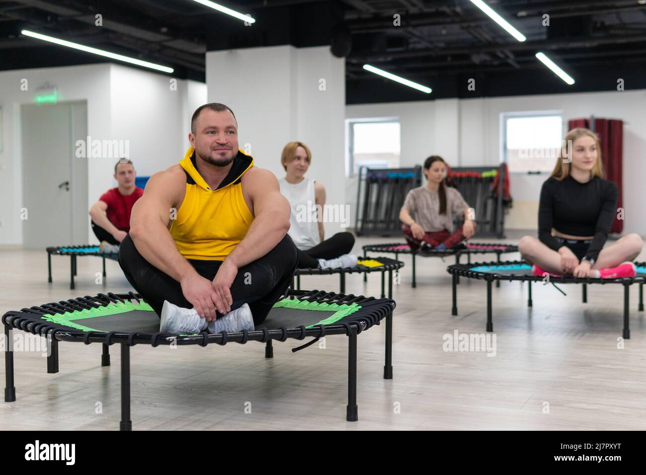 Women's and men's group on a sports trampoline, fitness training ...