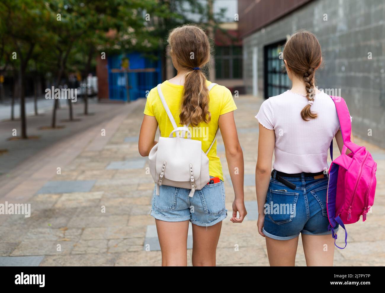 Young students girls walking down the street with a backpack. Back to ...