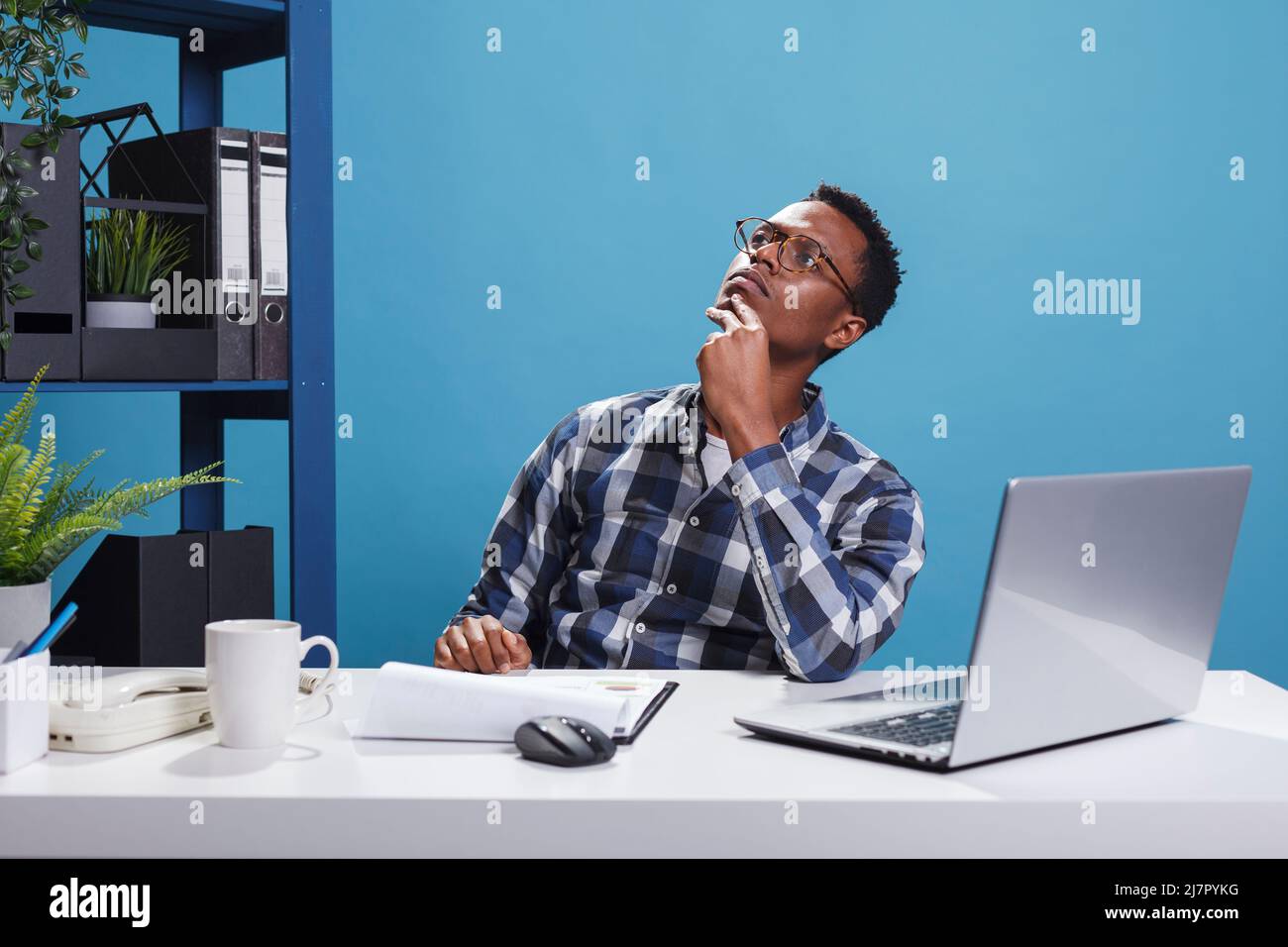 Smart looking pensive young adult man thinking about company management ...