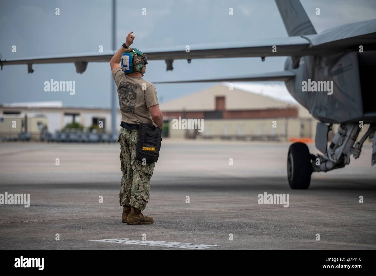 A U.S. Sailor signals an F/A-18 Super Hornet pilot with Strike Fighter ...