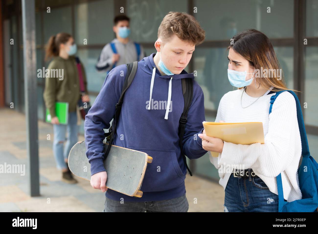 Teenagers in masks friendly talking outside Stock Photo - Alamy