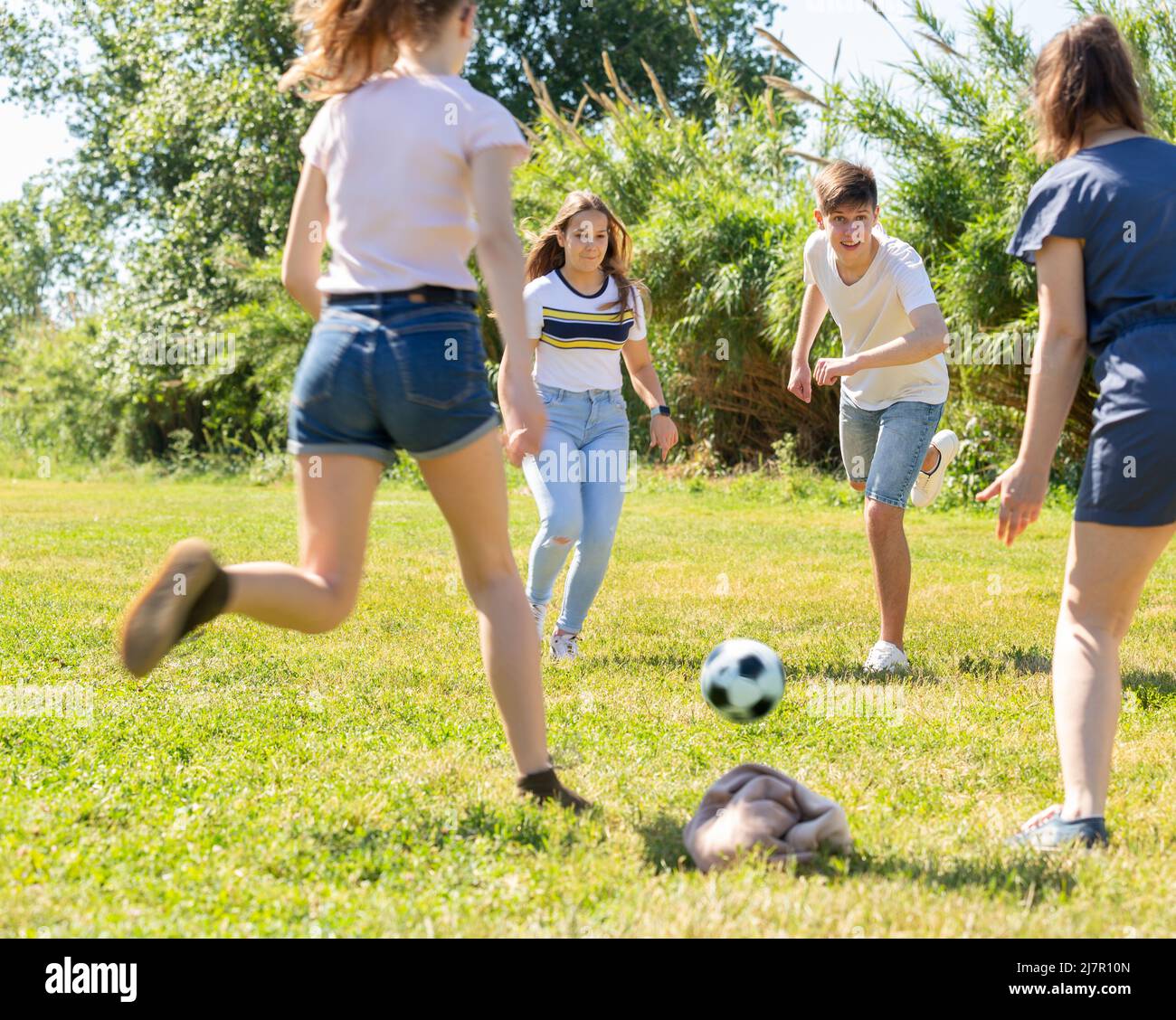 Teenagers playing football on green grass in summertime Stock Photo - Alamy
