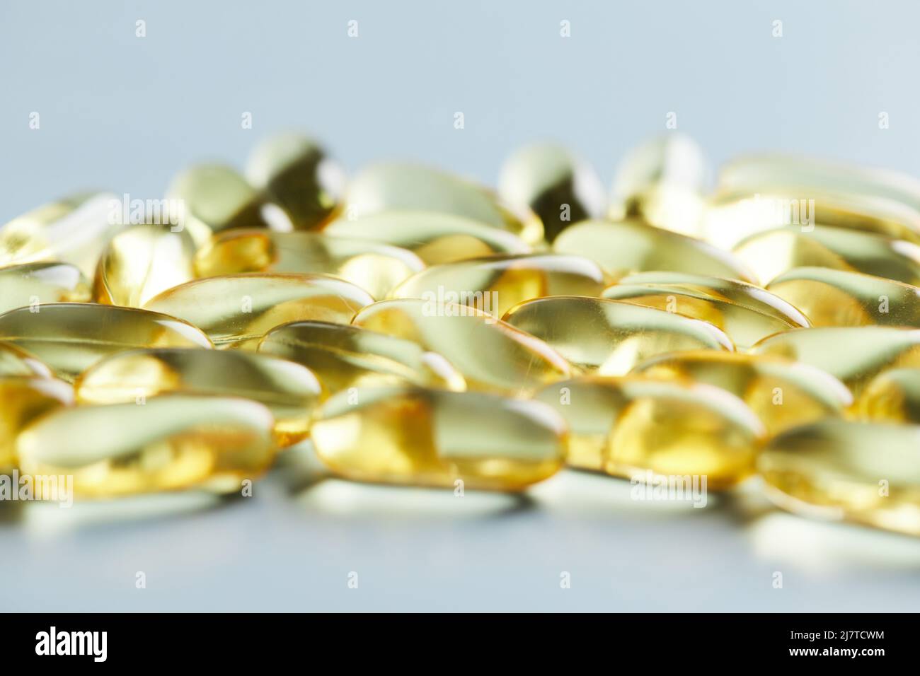 Capsules of omega-3 fatty acids on a blue background. The concept of ...