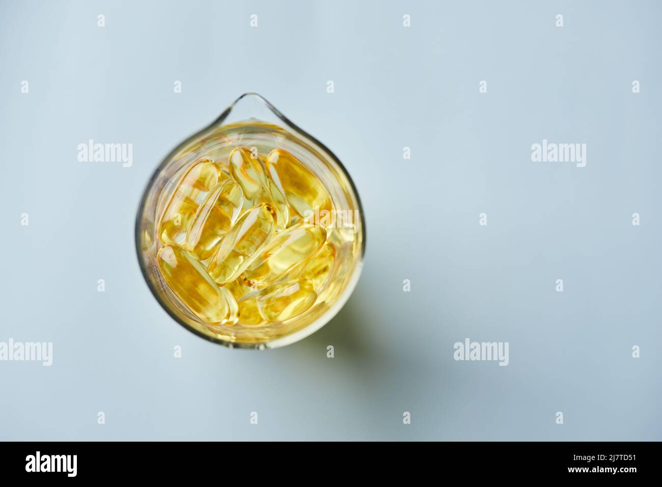 Capsules of omega-3 fatty acids on a blue background. The concept of ...