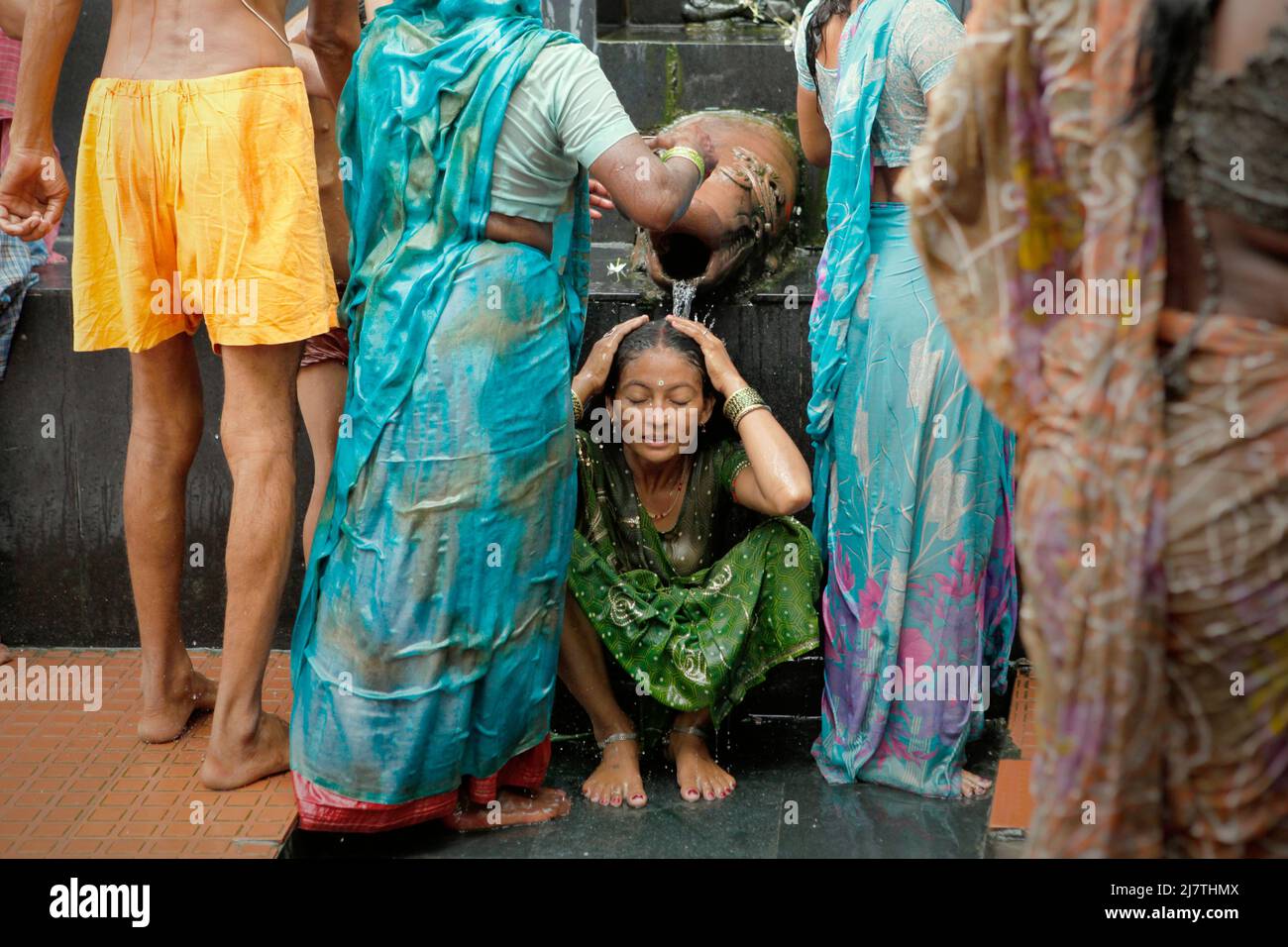 A woman pilgrim taking a bath in holy water from a hot spring, which is ...