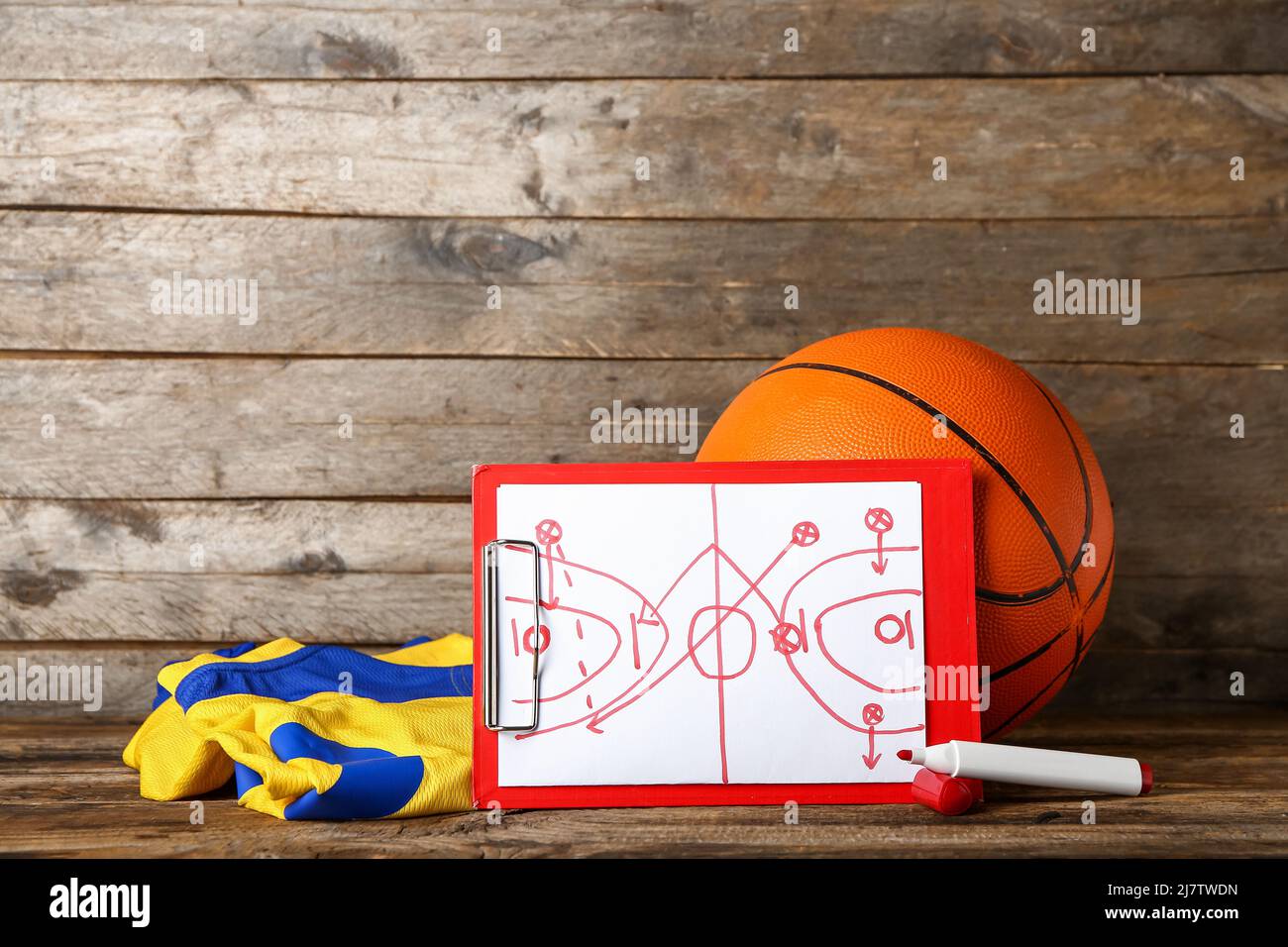 Clipboard with drawn scheme of basketball game, uniform and marker on ...
