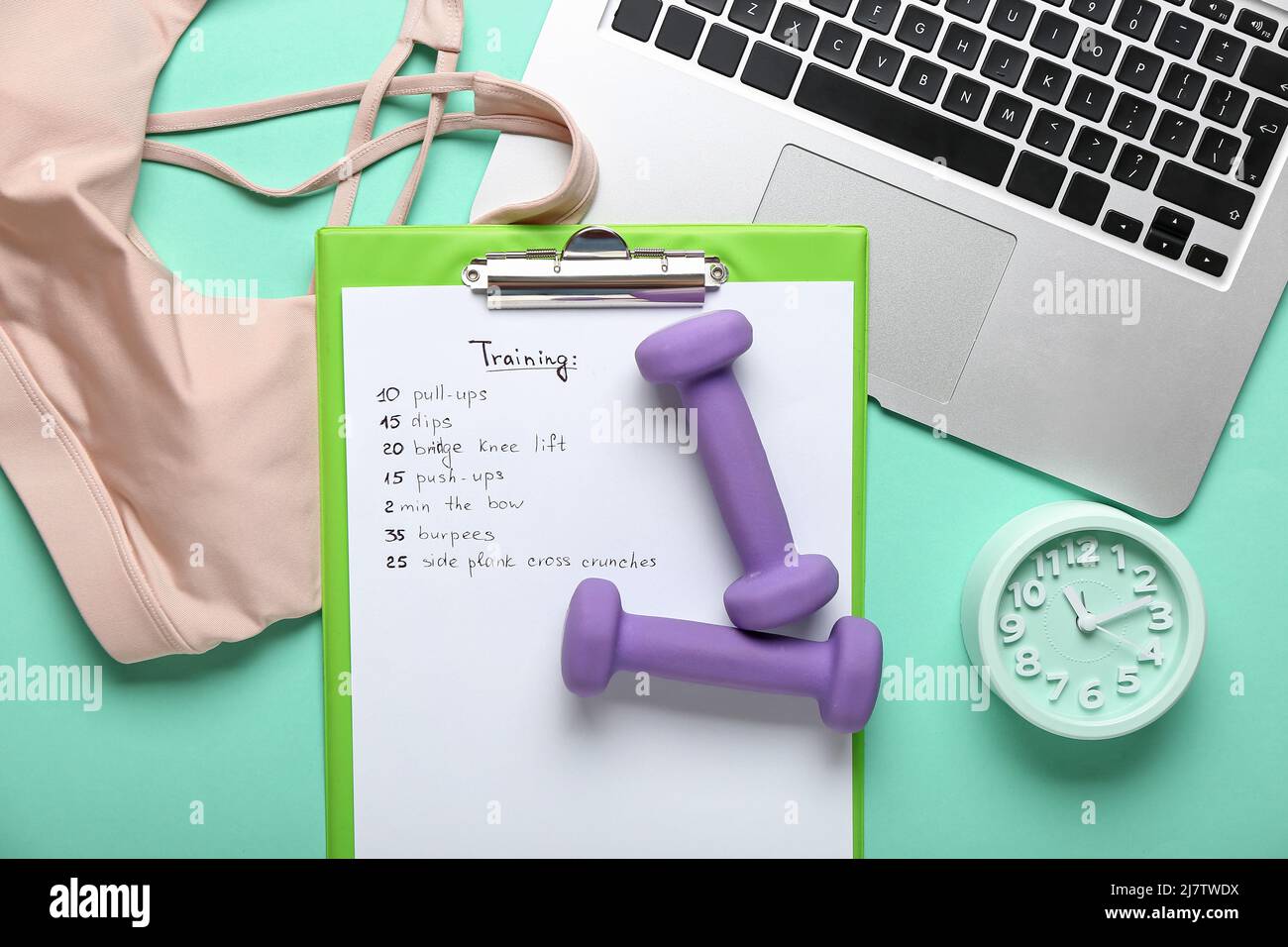 Clipboard with training plan, dumbbells, alarm clock, sport top and ...