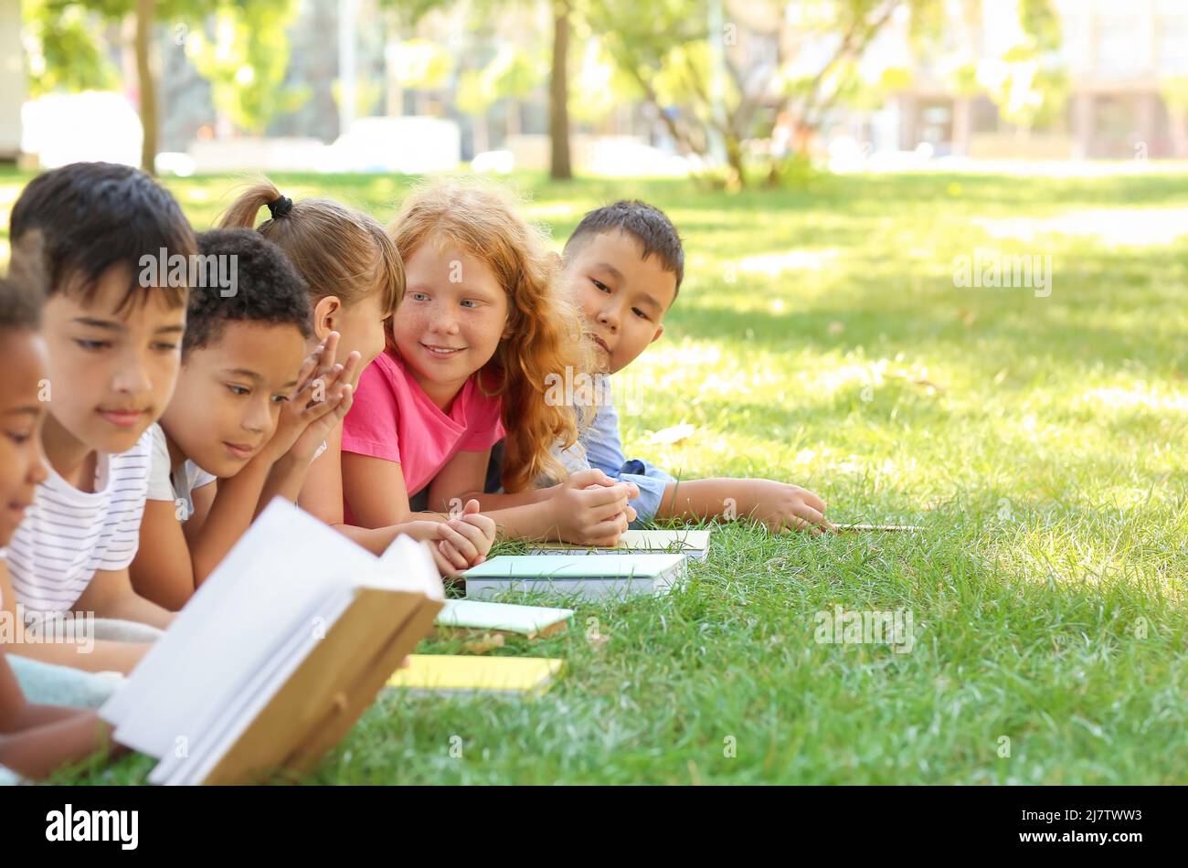 Cute little children reading books in park Stock Photo - Alamy