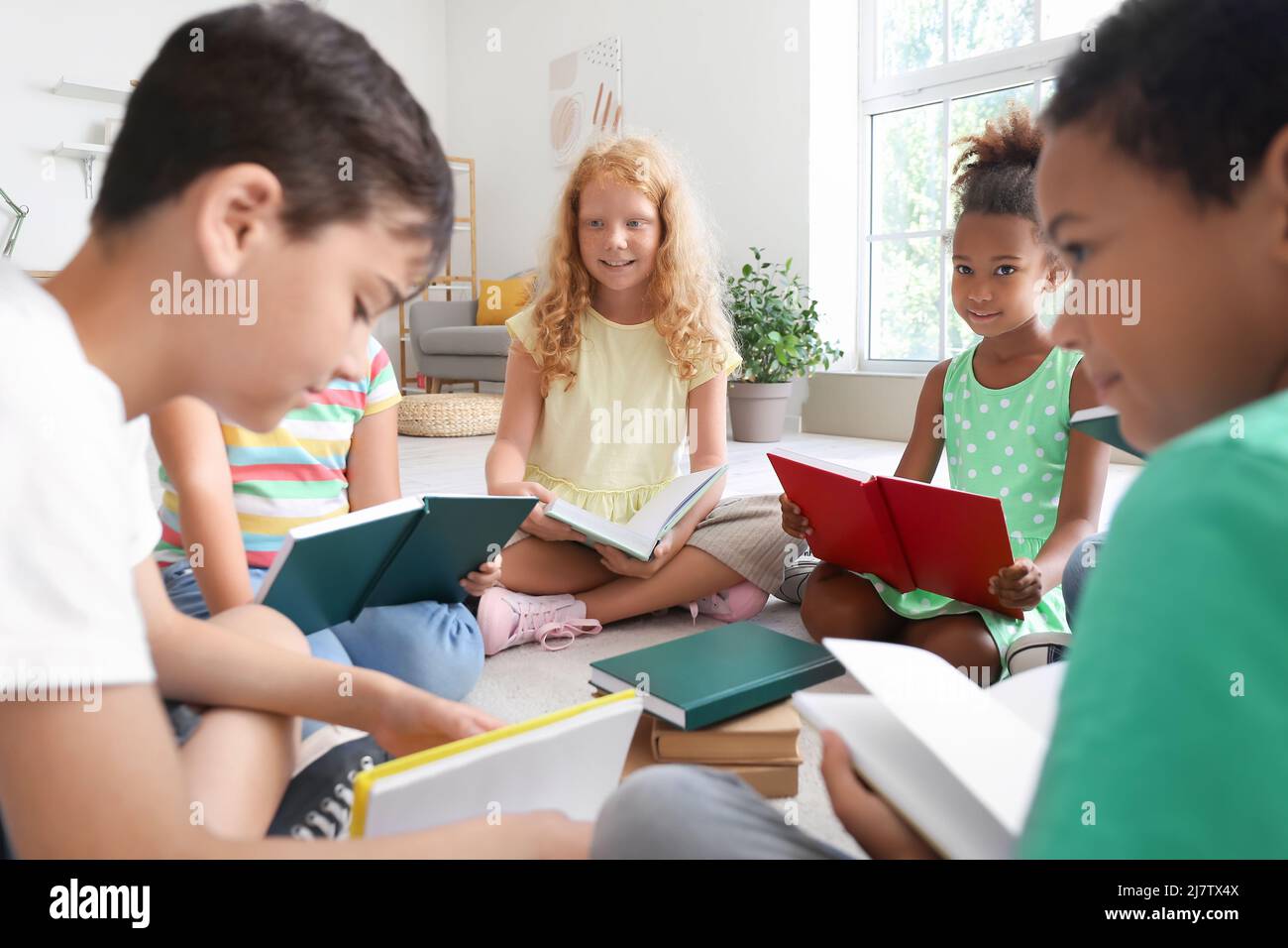 Little children reading books on floor Stock Photo - Alamy