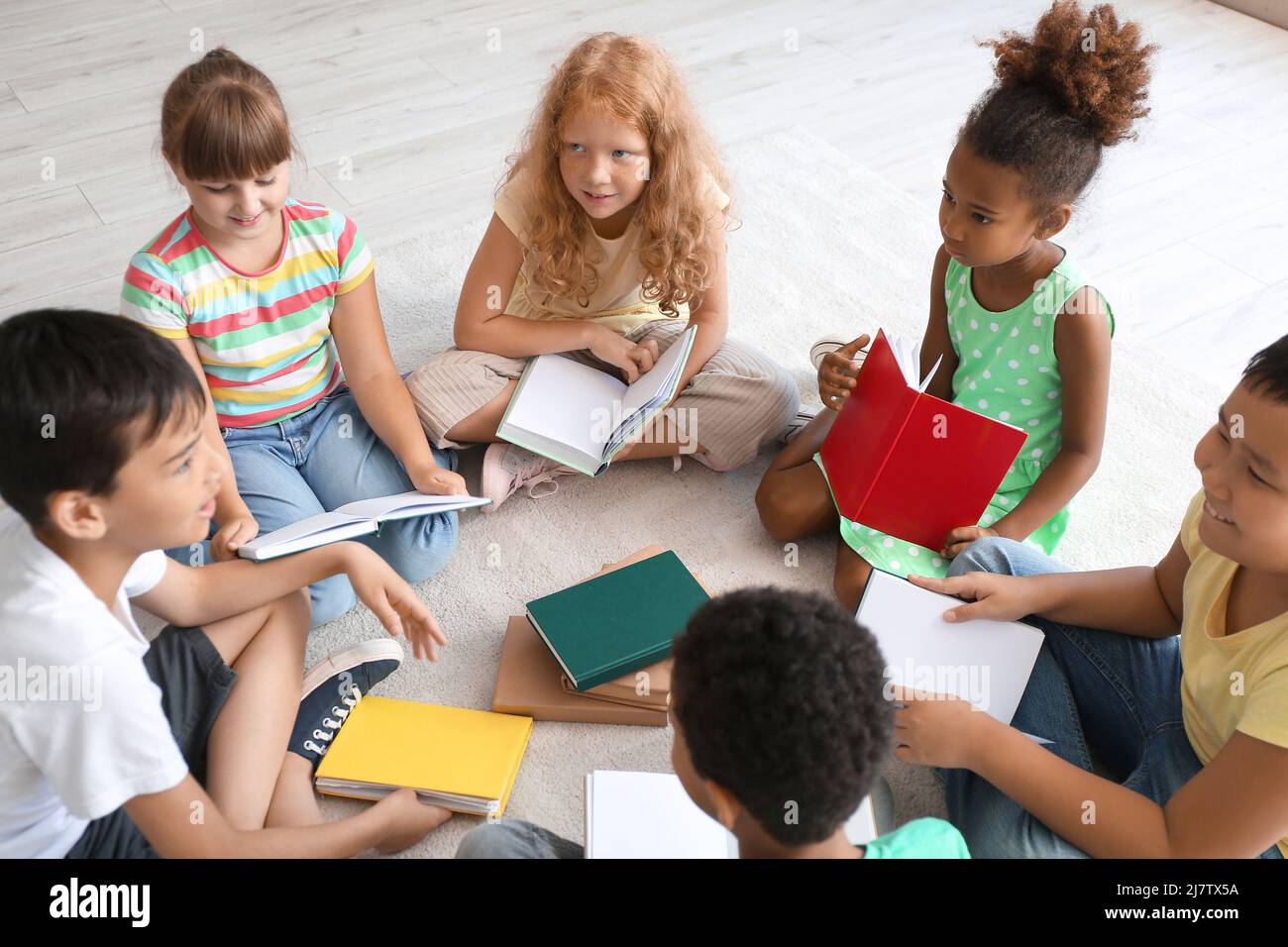 Little children reading books on floor Stock Photo - Alamy