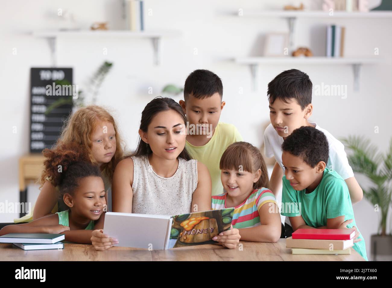 Little children having literature lesson with their teacher in ...