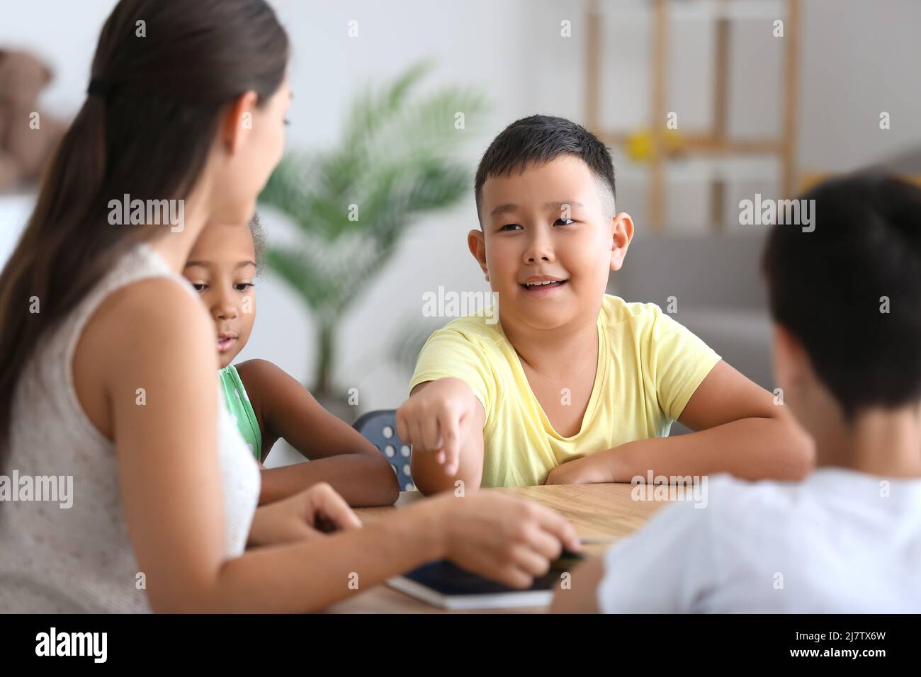 Little Asian boy having literature lesson in classroom Stock Photo - Alamy