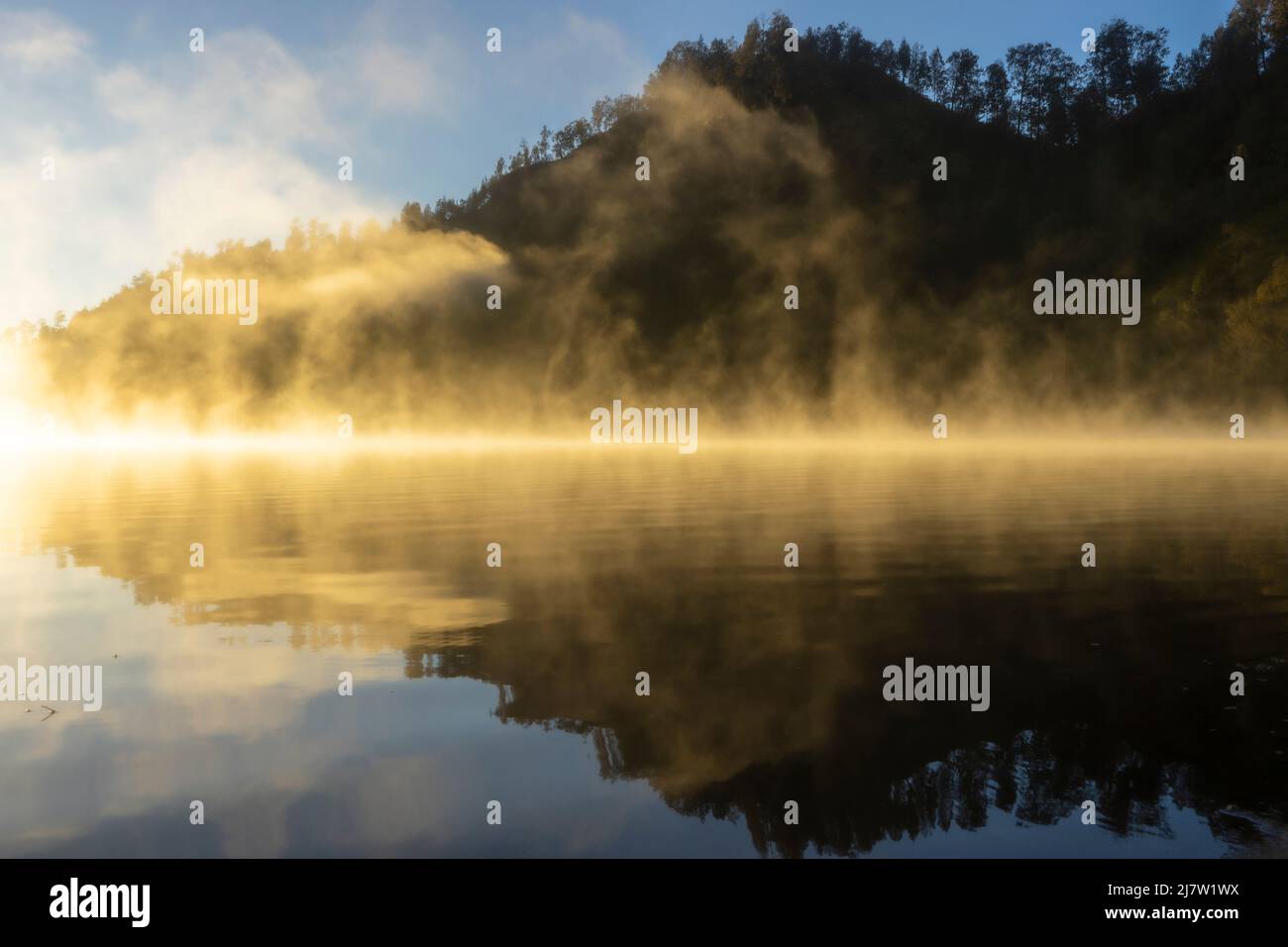 Rays of bursting sunlight in a misty lake of Ranu Kumbolo, Semeru ...