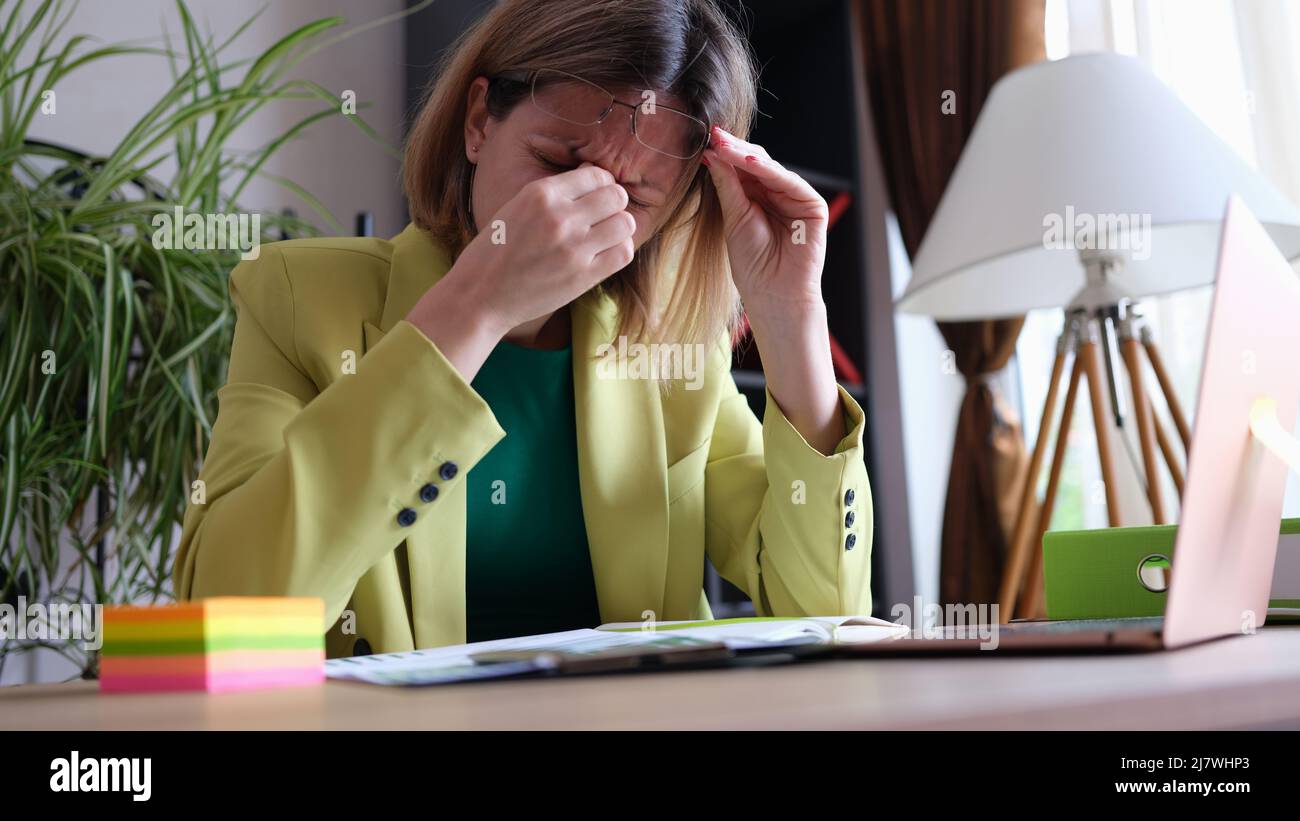 Tired business woman takes off glasses, feeling tired eyes from working ...
