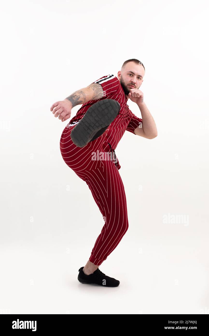 Tattooed man posing in studio on white background. Doing karate, fight ...