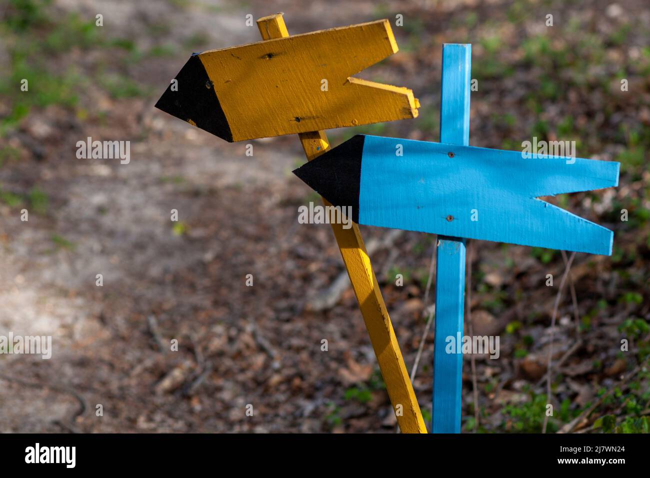 Yellow and blue painted arrows pointing the way on a path Stock Photo ...