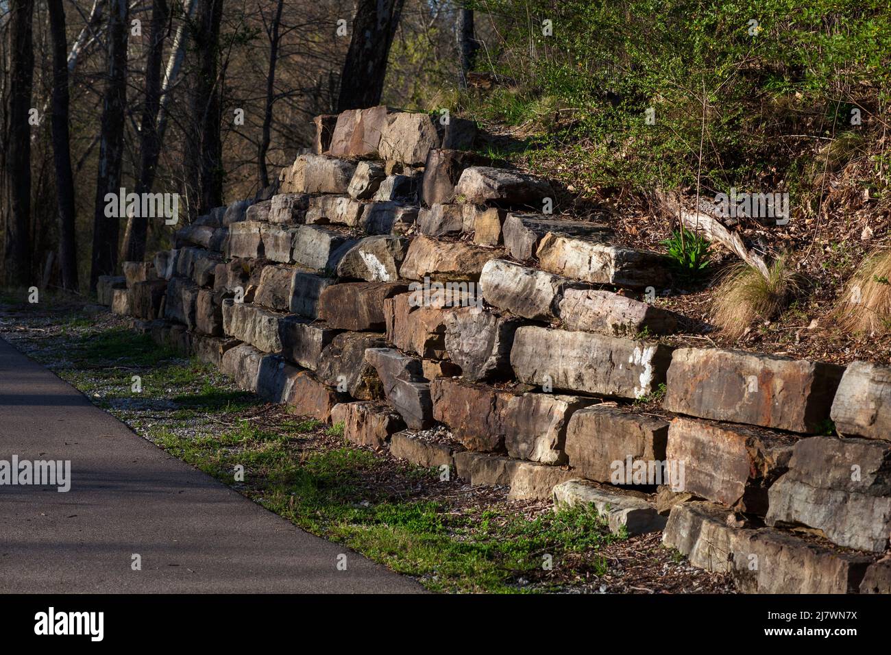 Rock wall next to a path in the park Stock Photo - Alamy