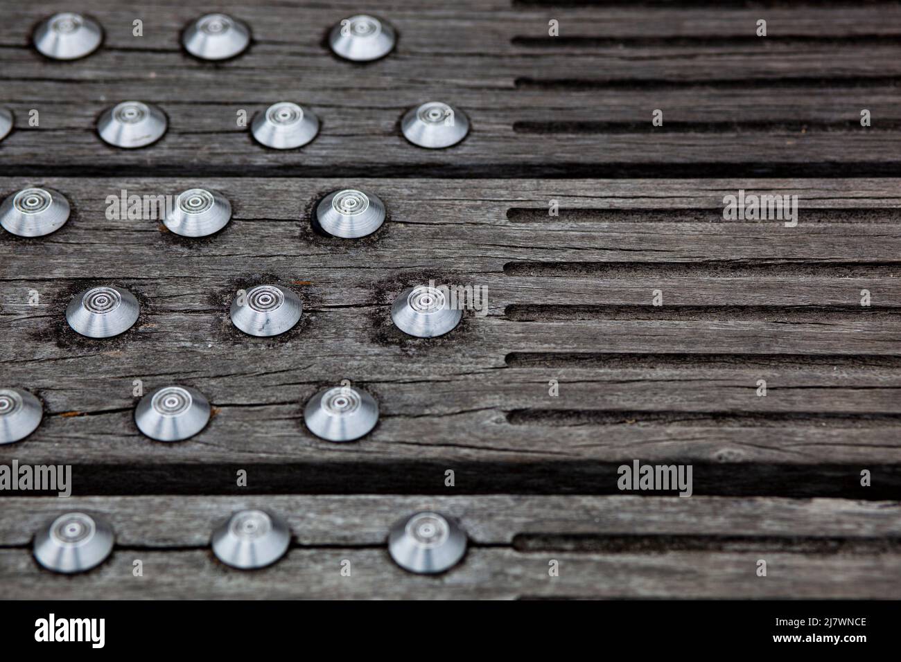 Circular rivets in wood deck Stock Photo - Alamy